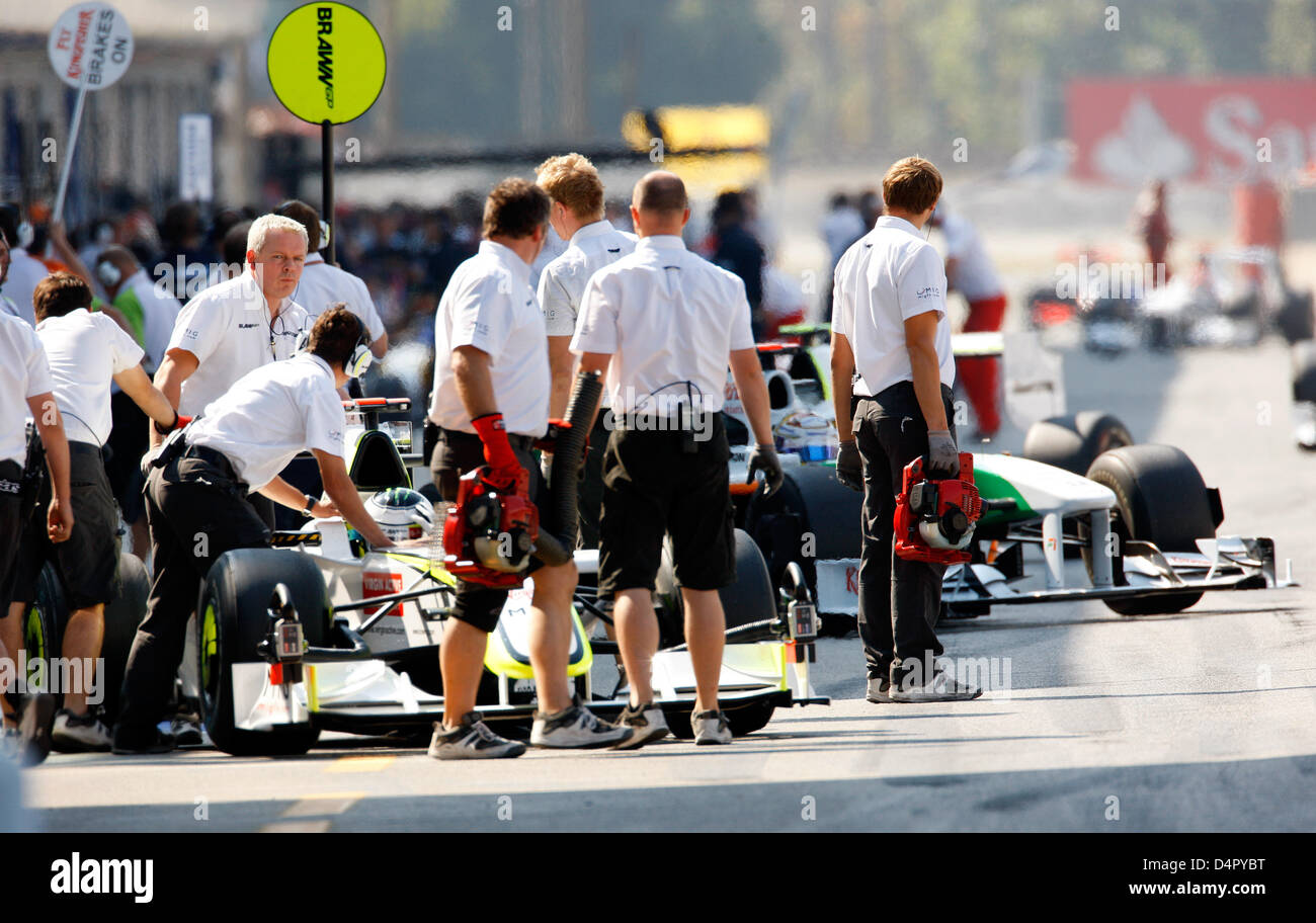 Mechanics of Force Brawn GP push the racing car during first practice ...