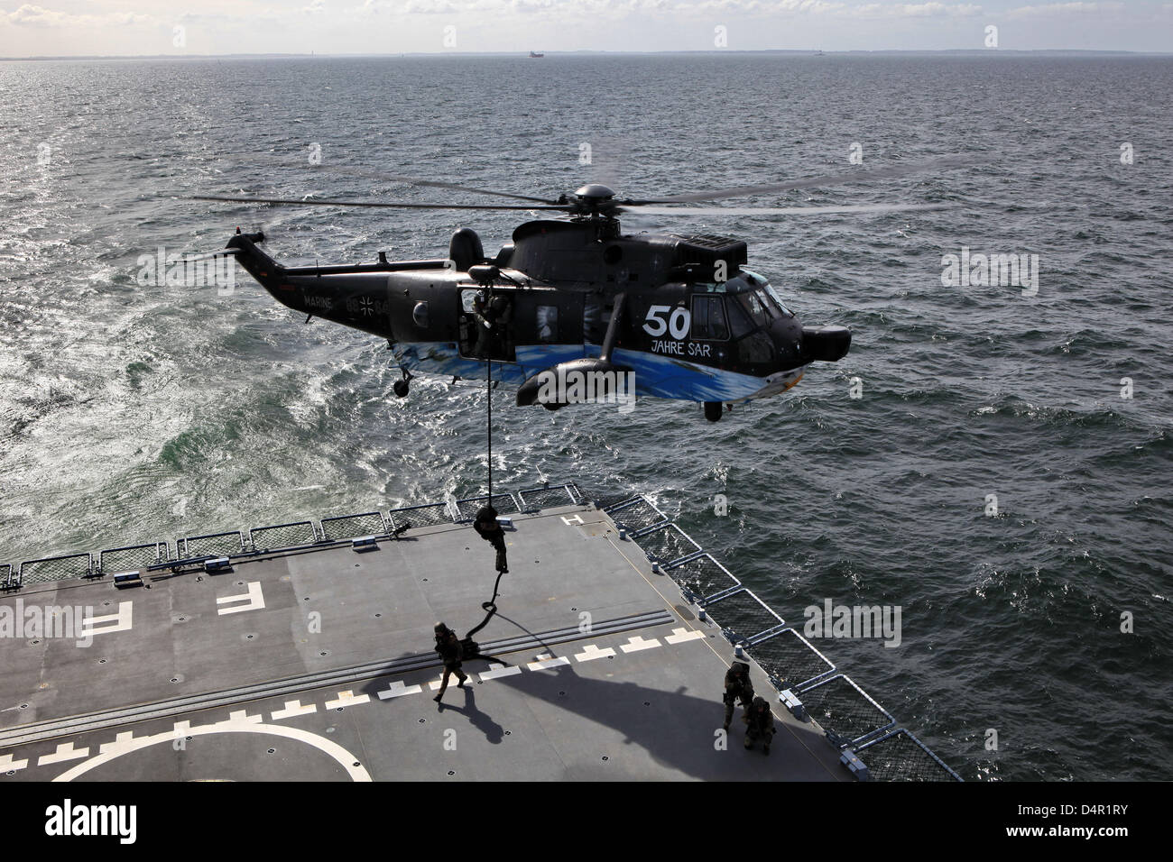 Soldiers of the Navy Special Forces (SEKM) rope down from a helicopter ...