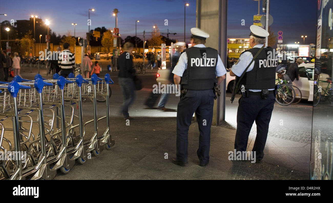 Two police officers with bullettproof vests and machine guns patrol at ...