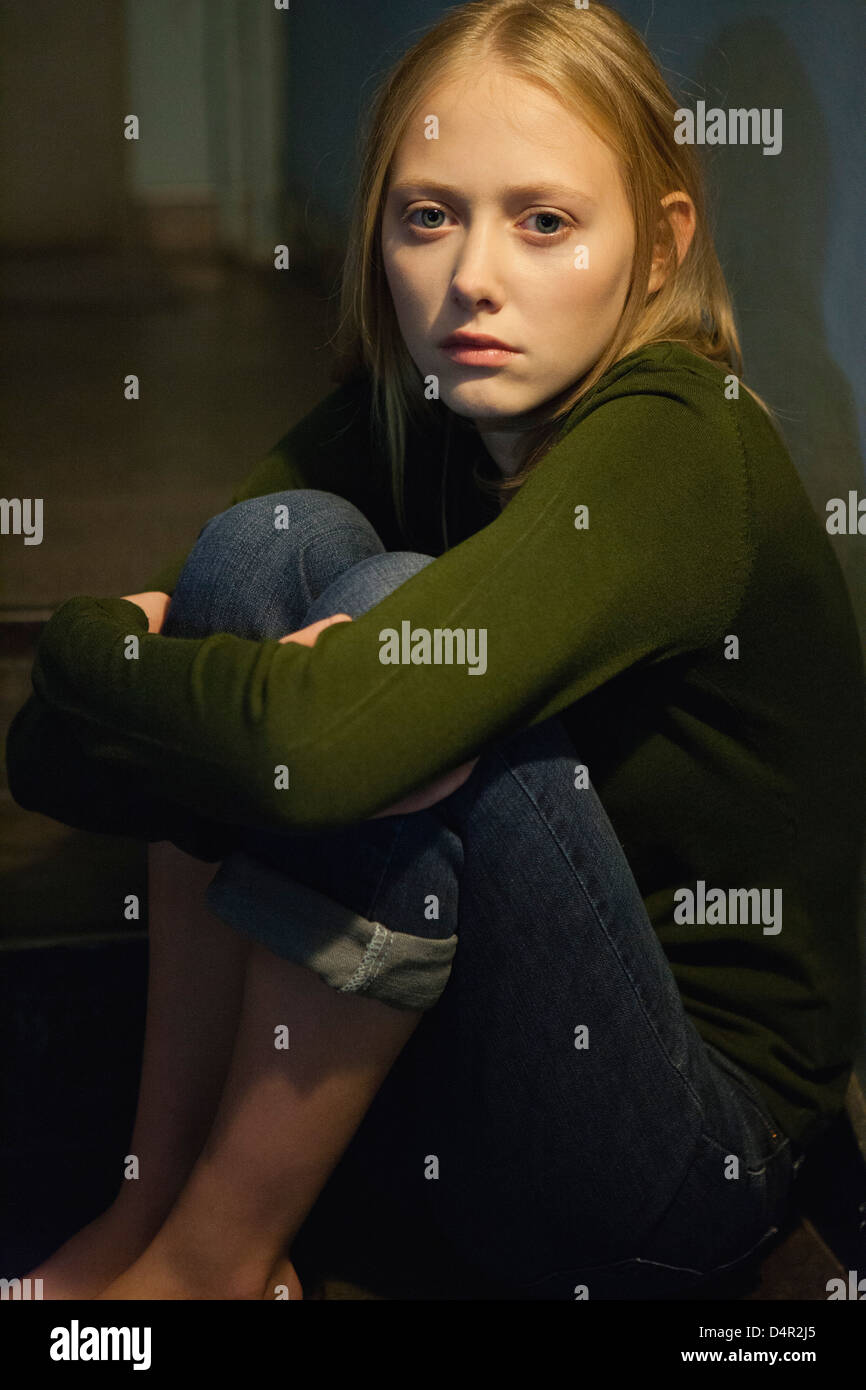 Young woman hugging knees, portrait Stock Photo - Alamy