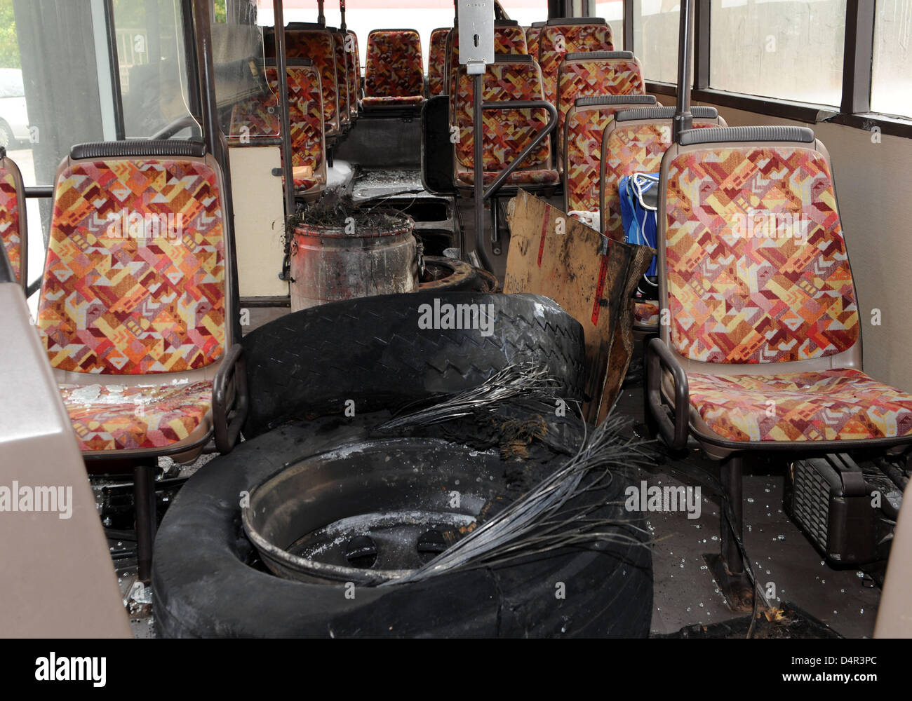 The burnt-out wreck of a school bus stands on the premises of the bus ...