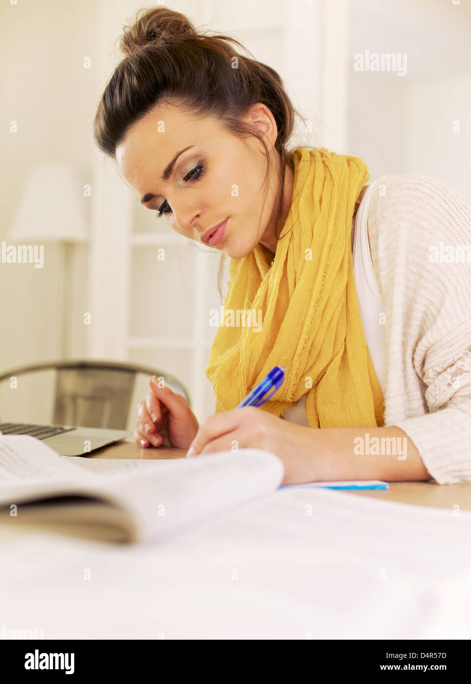 Indoor woman busy writing something and studying all her books Stock ...