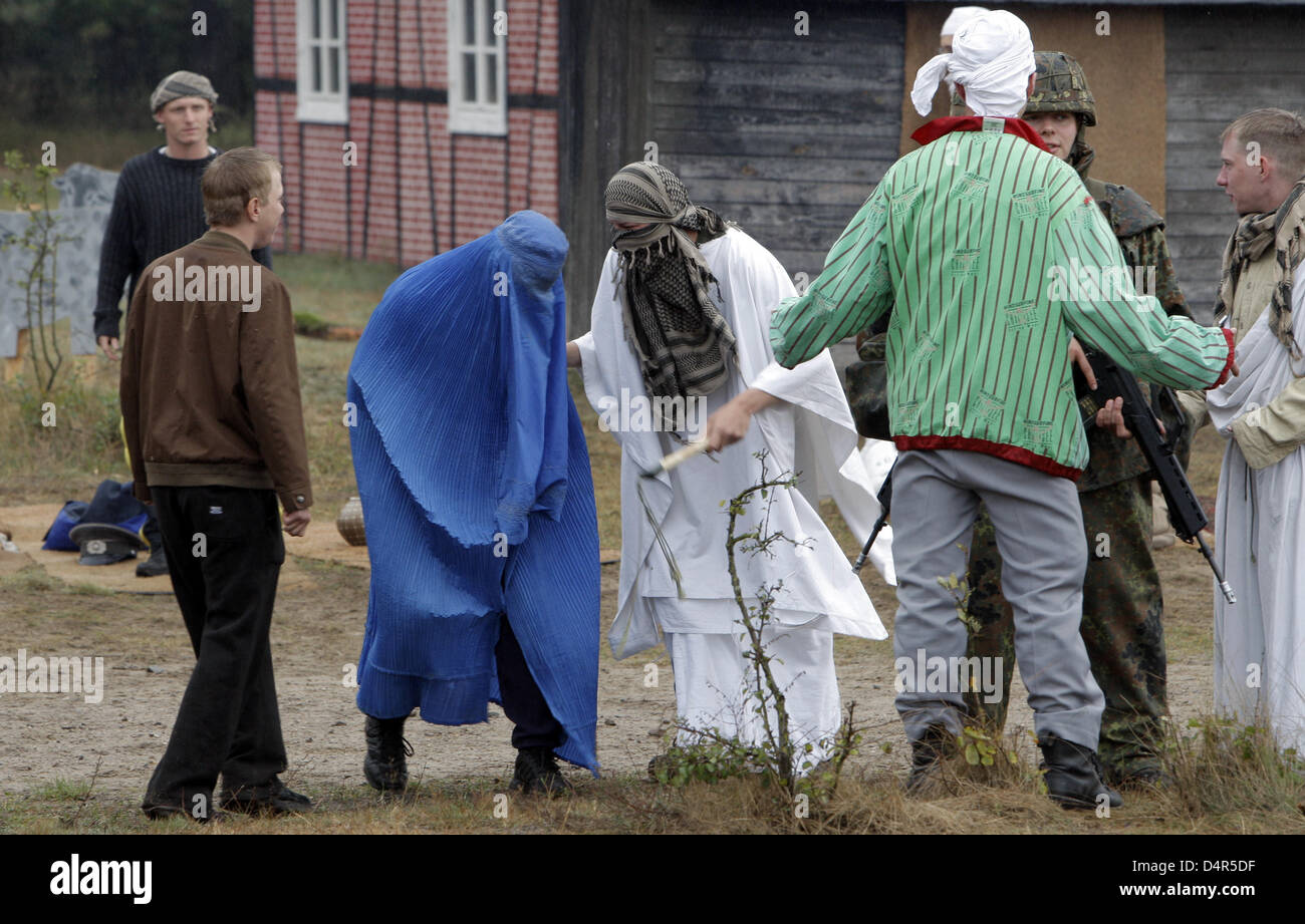A German Bundeswehr soldier and other soldiers dressed as Afghan ...