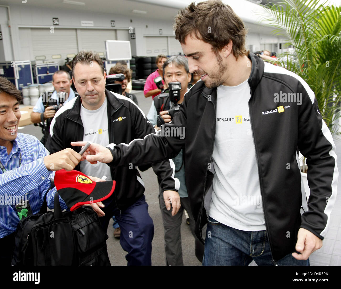 Spanish Formula One driver Fernando Alonso of Renault F1 Team signs an ...