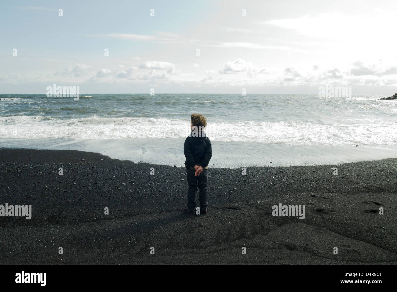 Boy looking horizon facing the sea, iceland Stock Photo - Alamy