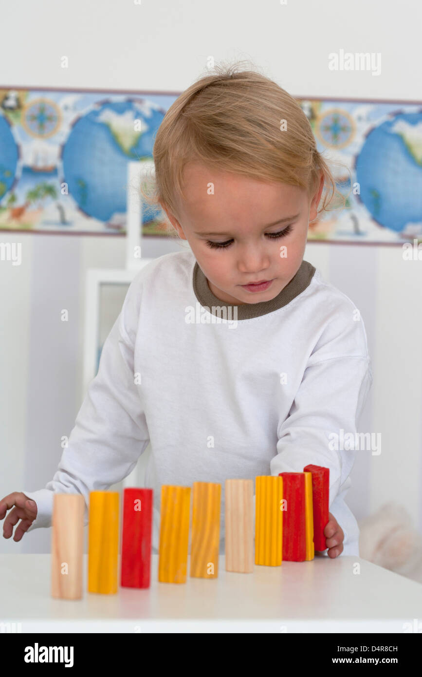 Baby boy carefully lining up blocks Stock Photo - Alamy