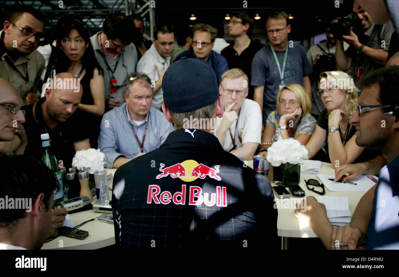 German Formula One driver Sebastian Vettel (C) of Red Bull Racing gives ...