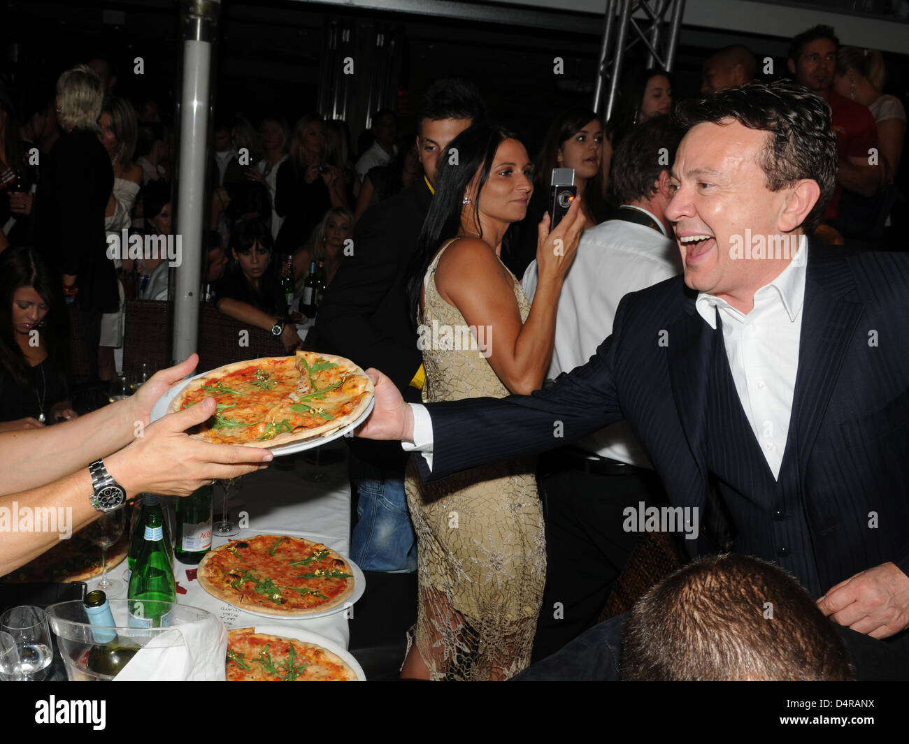 Singer Pupo hands out a pizza with gold topping at the summer party of ...