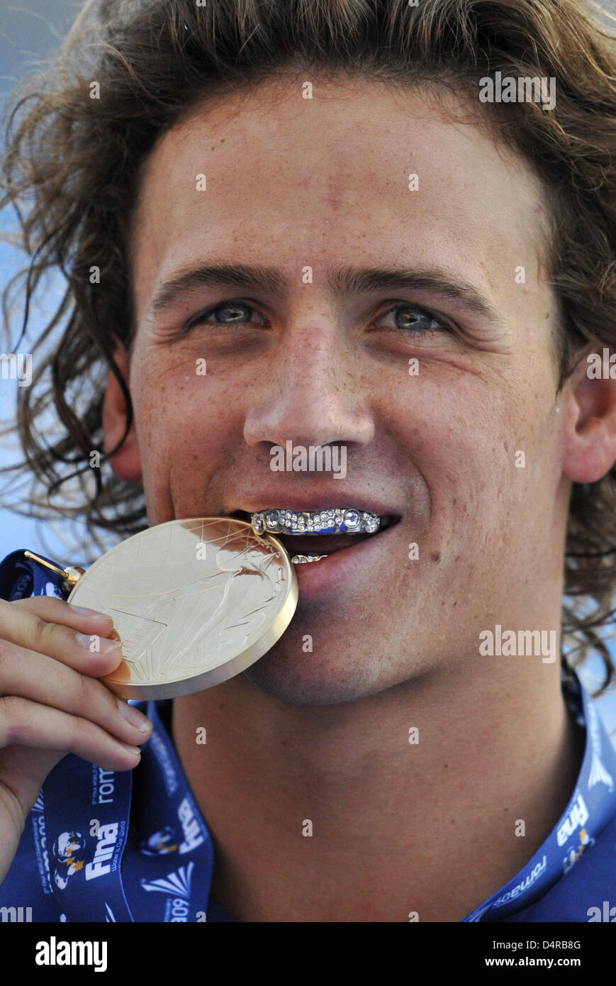 US swimmer Ryan Lochte poses with his gold medal after his victory in ...