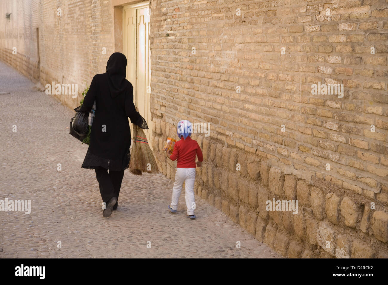 The Picture Shows A Veiled Woman And Her Daughter Wearing A Colourful