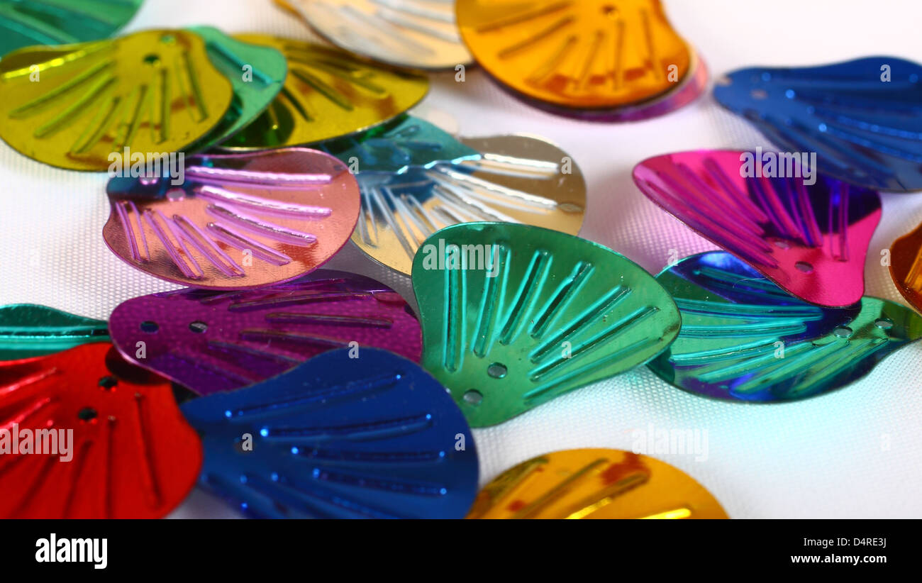 Multi coloured sshell sequins on white background Stock Photo - Alamy