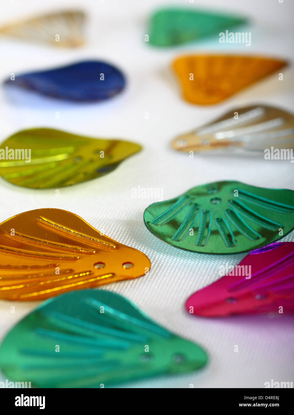 Multi coloured sshell sequins on white background Stock Photo - Alamy