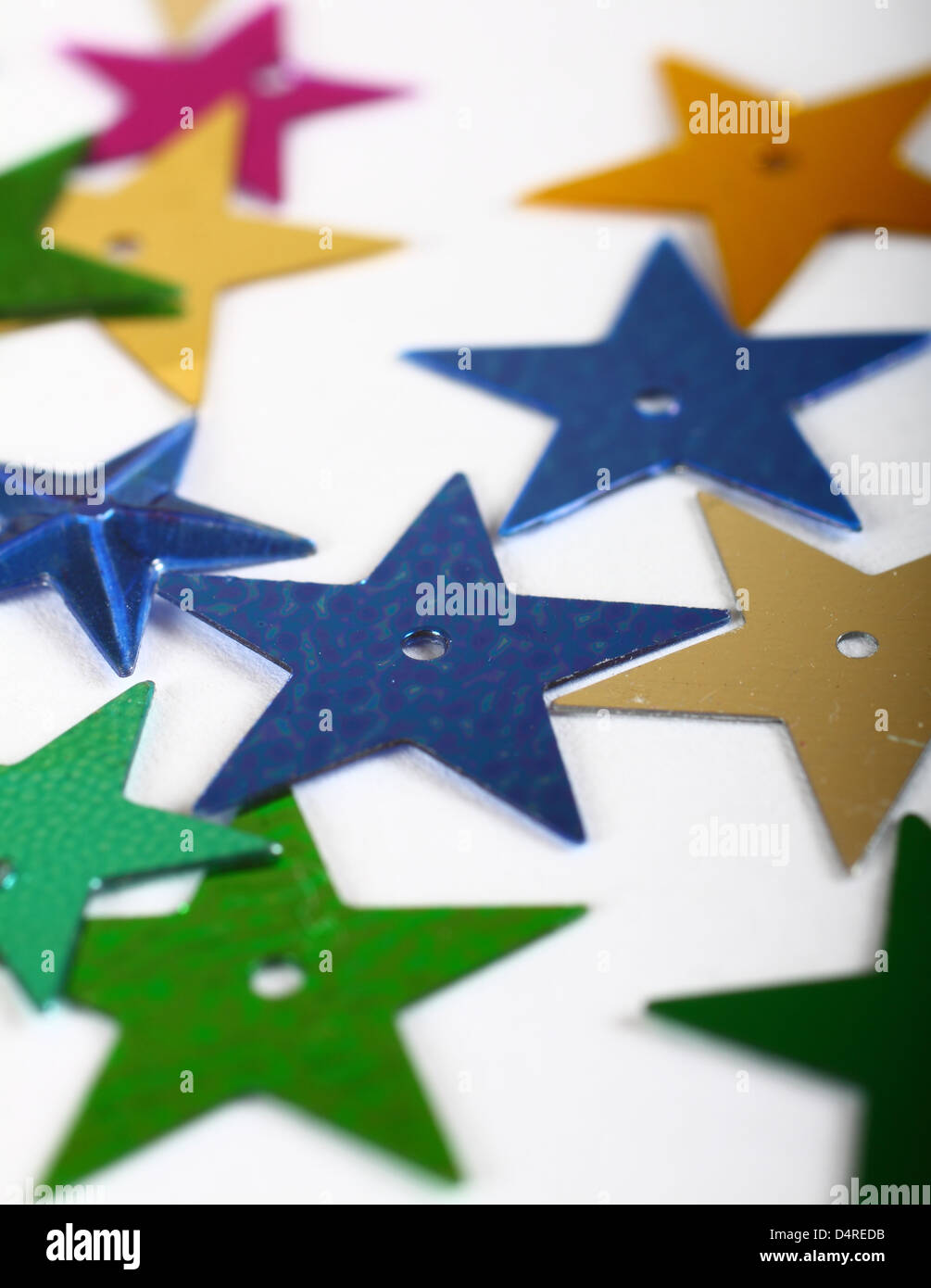 Multi coloured star sequins on white background Stock Photo - Alamy