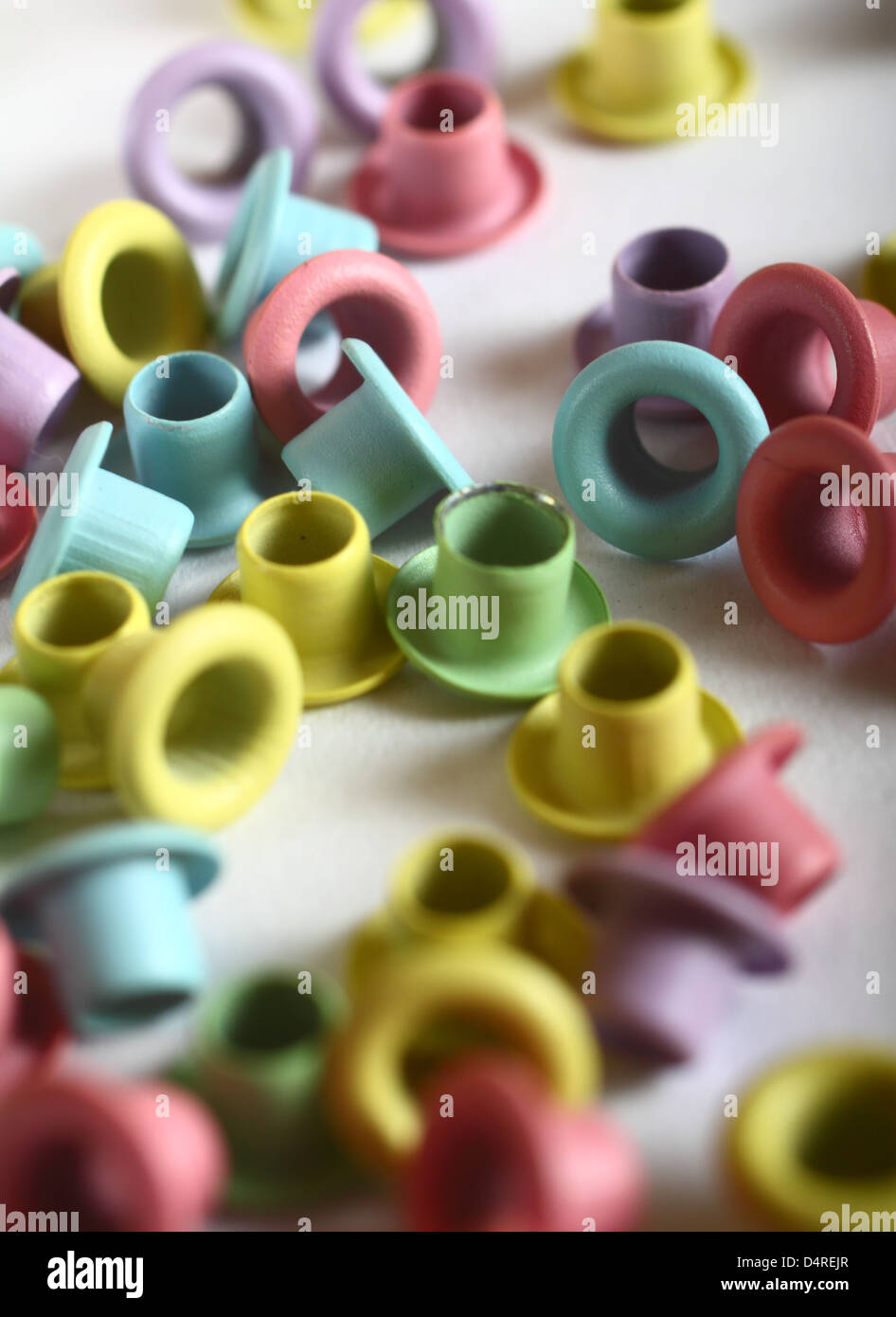 Colourful craft eyelets on white background Stock Photo - Alamy