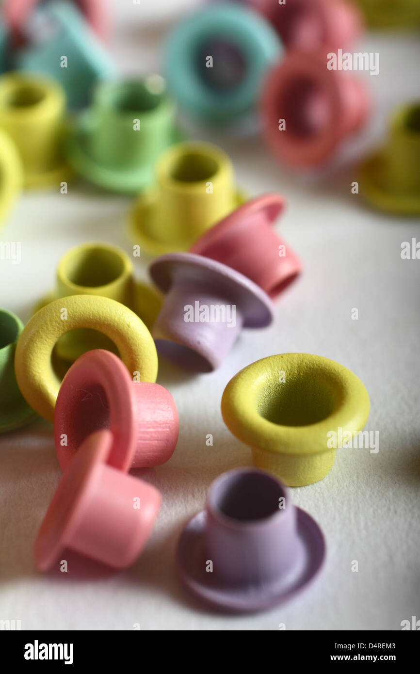 Colourful craft eyelets on white background Stock Photo - Alamy