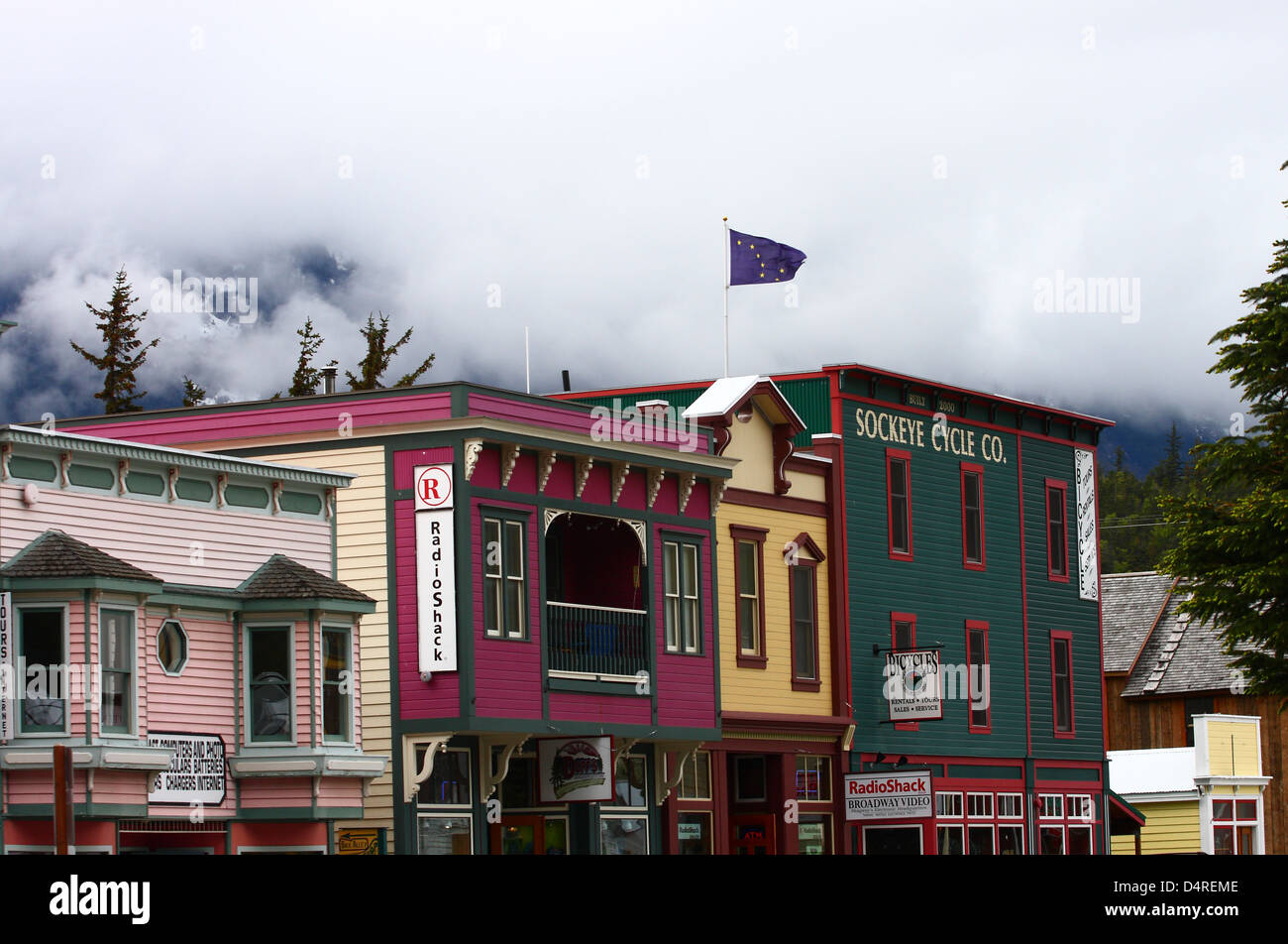 Colorful buildings on the street of Skagway Alaska with Alaskan flag ...