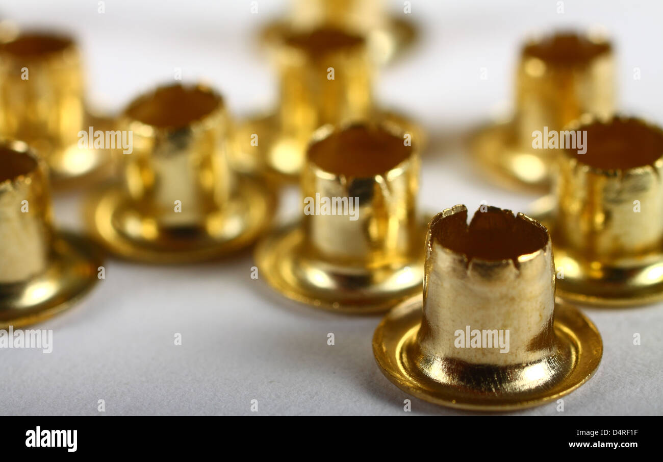 Brass craft eyelets on white background Stock Photo - Alamy