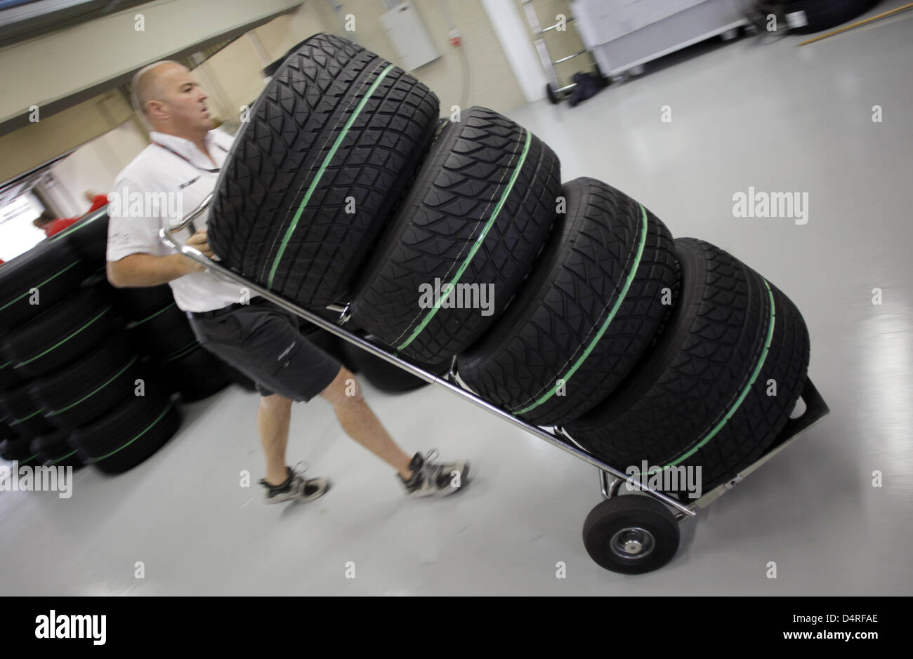 A mechanic of Brawn GP pushes tyres in the pits at Jose Carlos Pace ...
