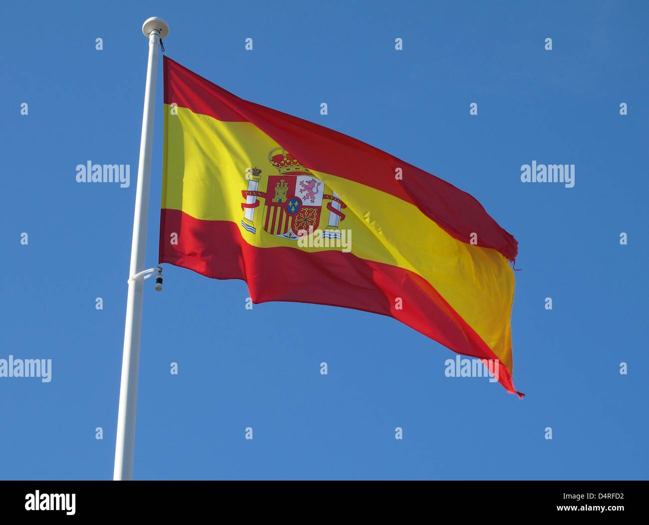 The Spanish national flag sways in the wind in front of a backdrop of a ...