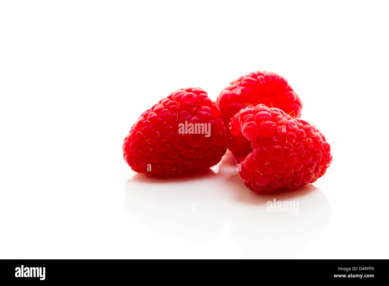 Heap of organic raspberries on white background Stock Photo - Alamy