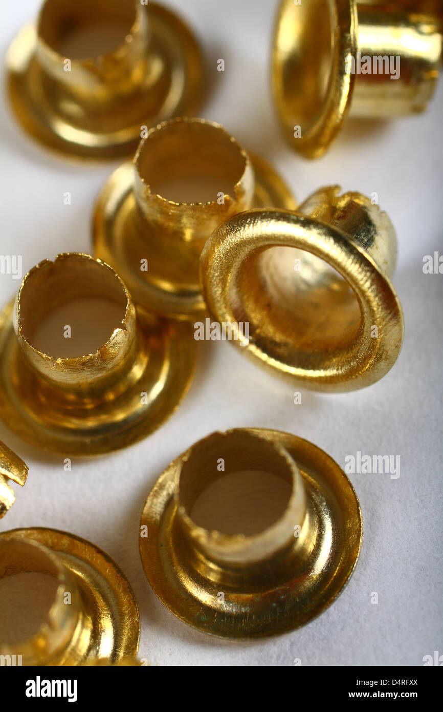 Brass craft eyelets on white background Stock Photo - Alamy