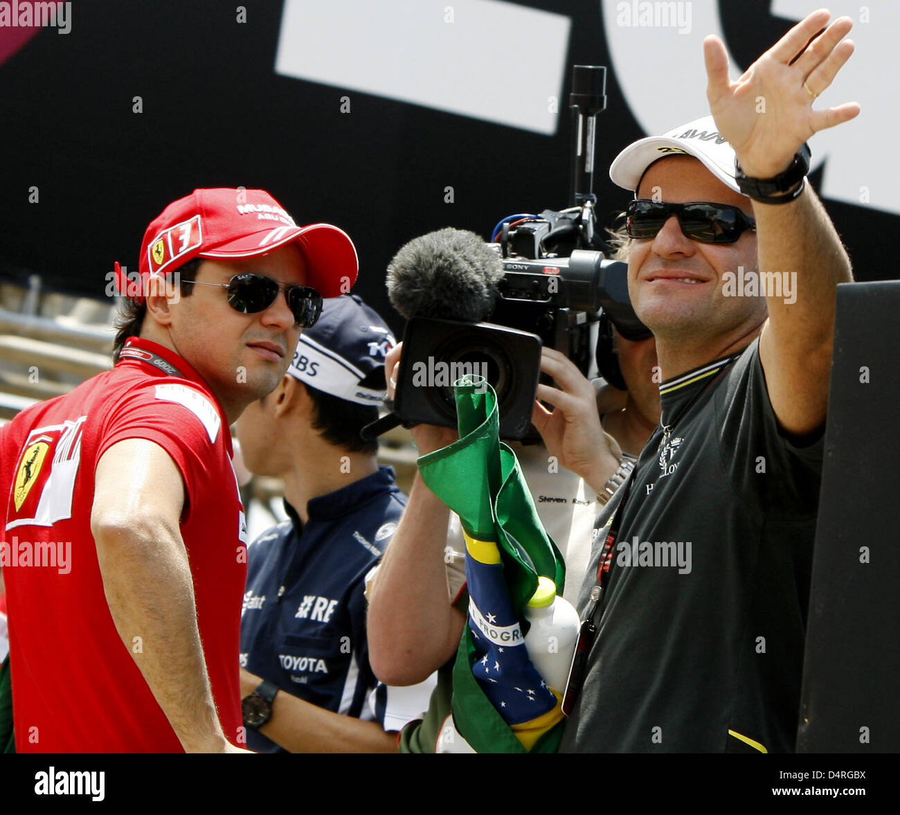 Brazilian Formula One driver Rubens Barrichello (R) of Brawn GP waves a ...