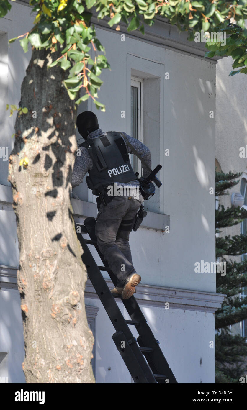A special forces policeman enters a building by a ladder during a ...