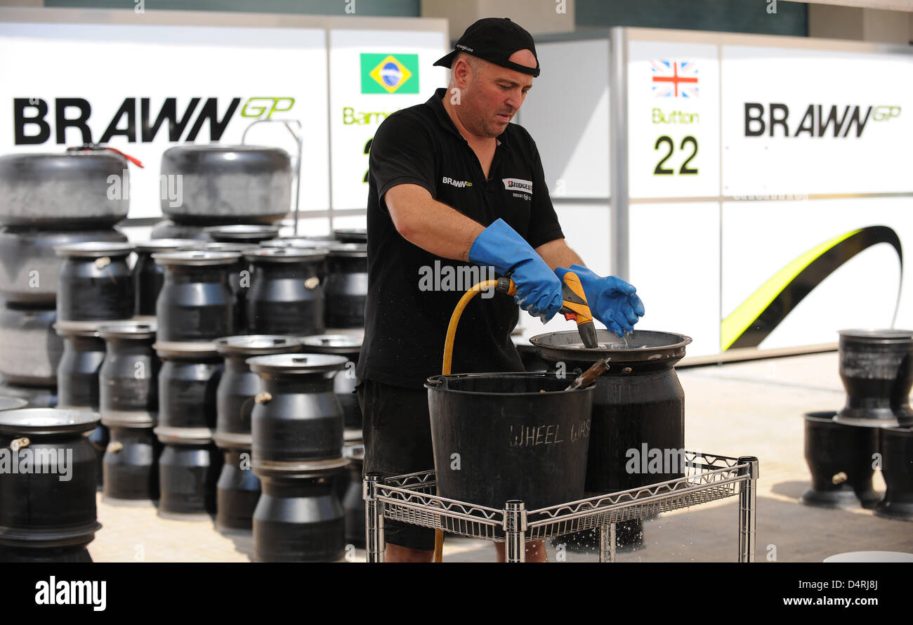 A mechanic of Brawn GP cleans tyres in the paddock at the newly built ...