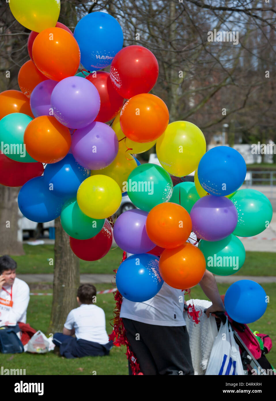A man walking through the park with balloons Stock Photo - Alamy
