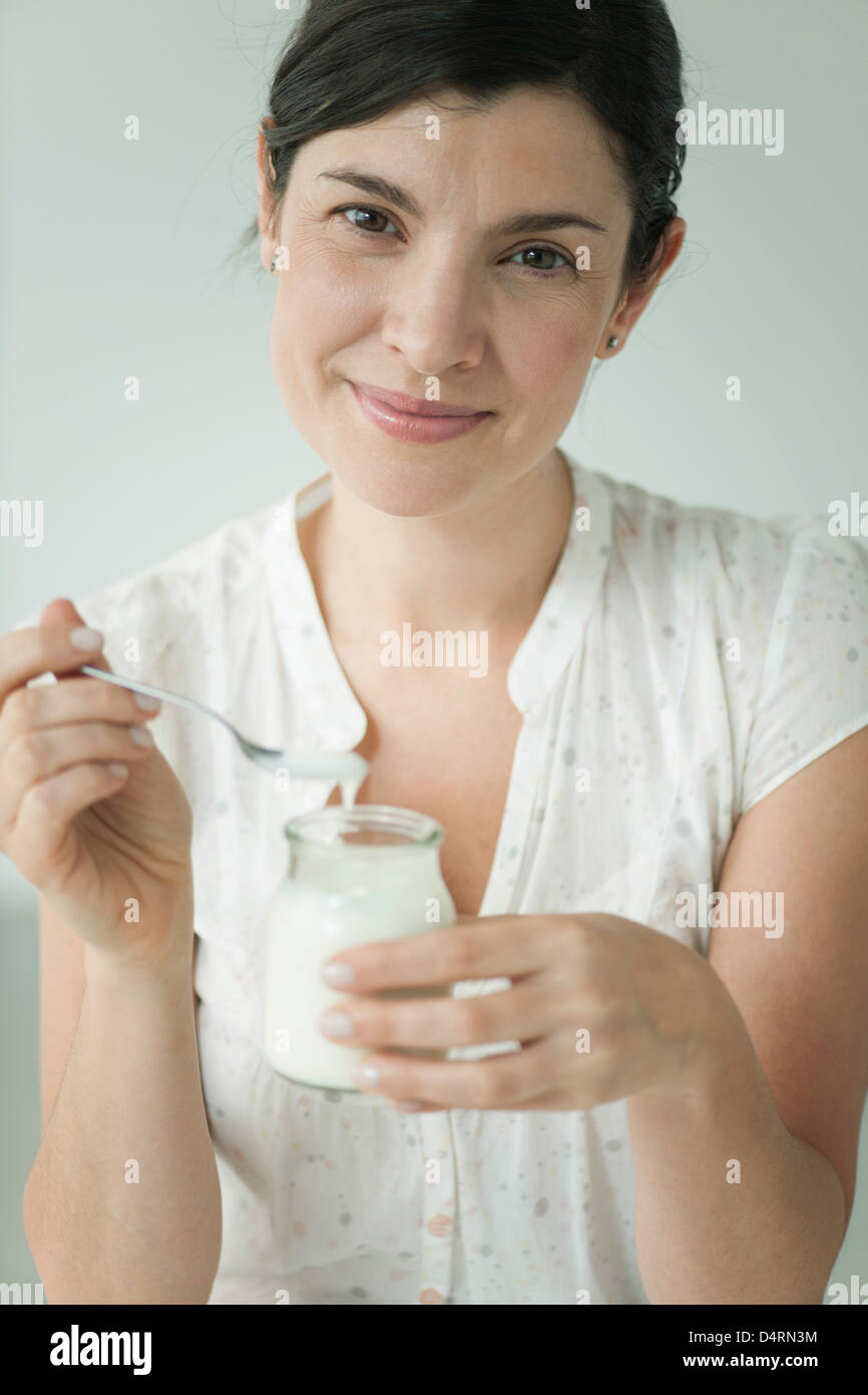 Woman eating yogurt, portrait Stock Photo - Alamy