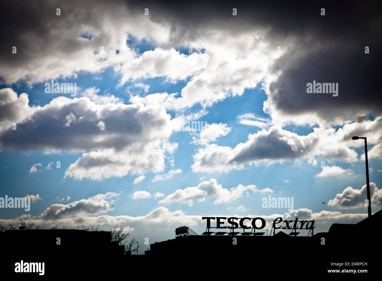Tesco Extra shop sign against blue sky and dark clouds Stock Photo - Alamy
