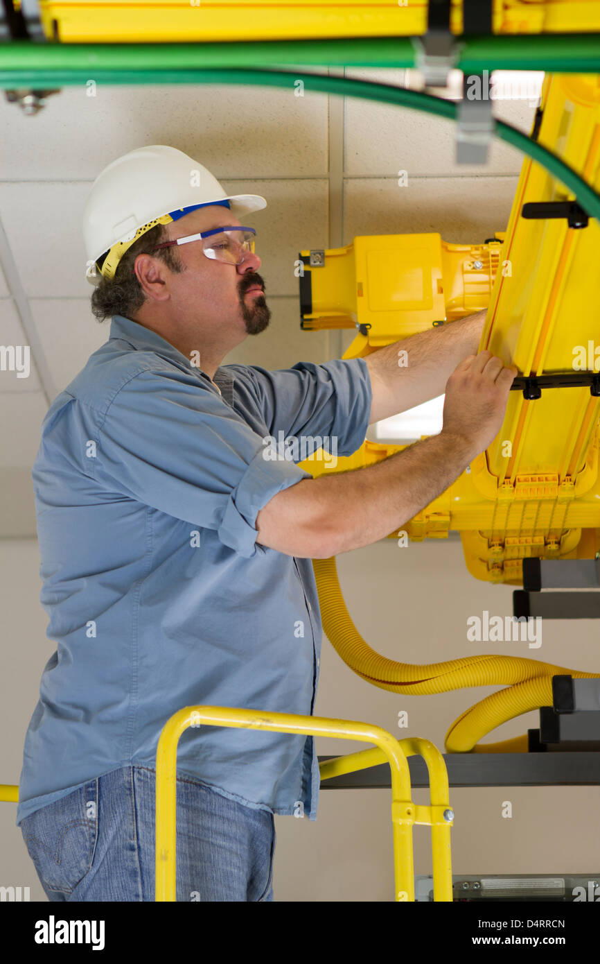 A telecommunication switch worker inspecting Fiberoptic cables in the ...