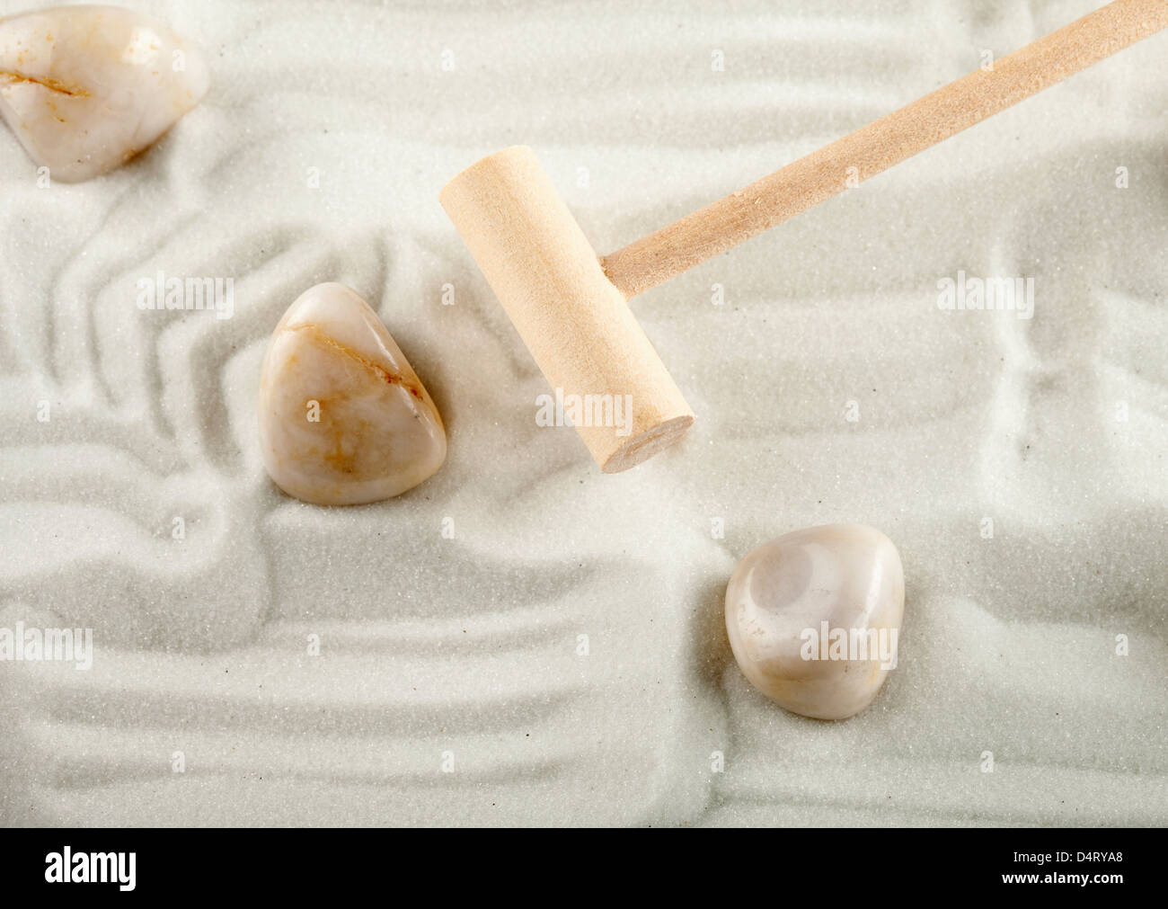 Stones, sand and rake of a zen garden Stock Photo - Alamy