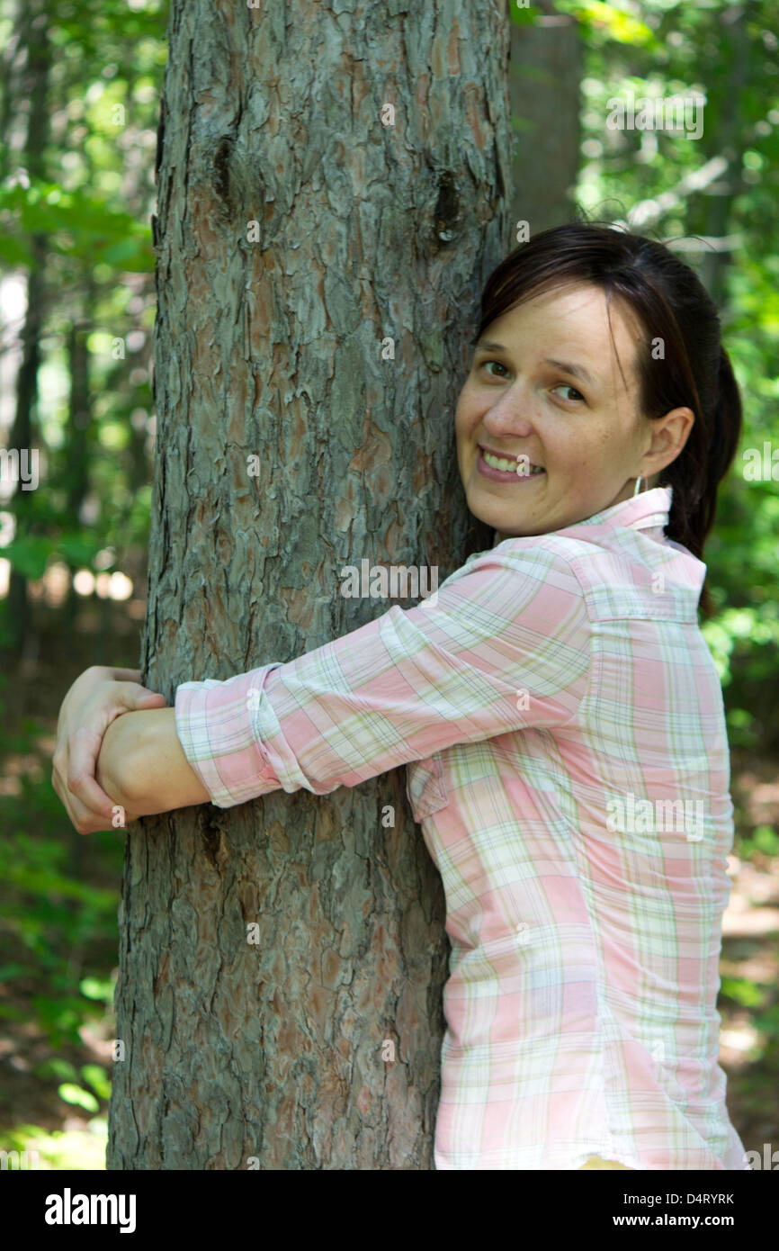 Young woman hugging a tree Stock Photo - Alamy