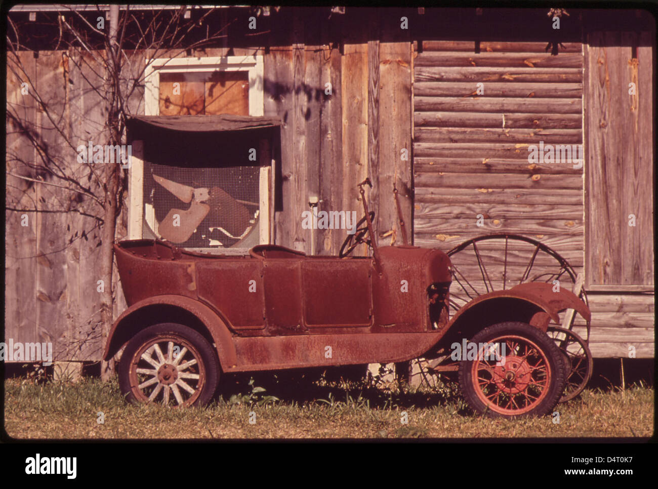 A photograph showing an abandoned automobile, part of the DOCUMERICA ...