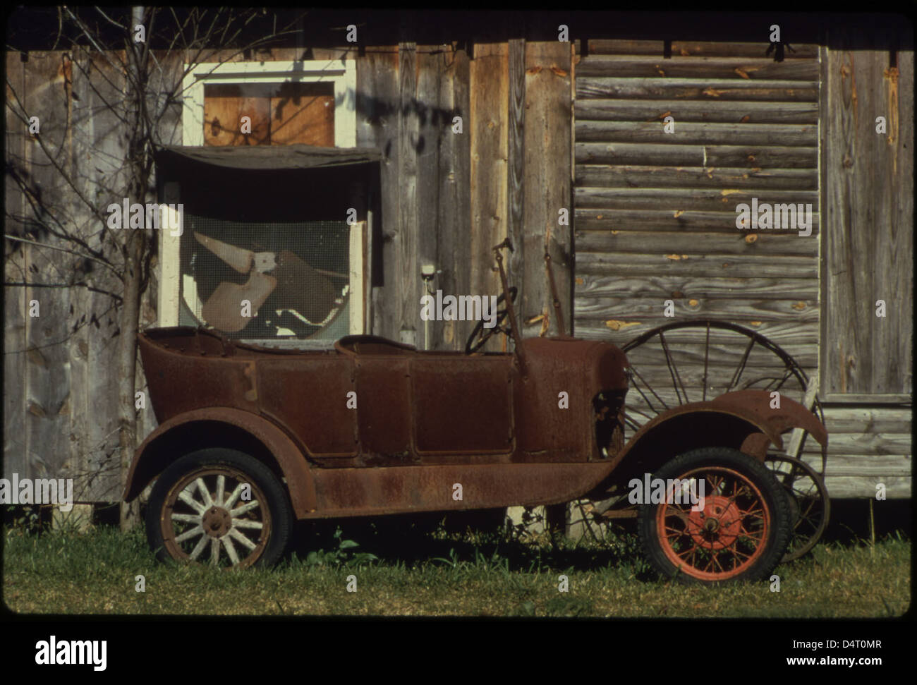 An antique car parked in front of a barn, photographed in May 1972 ...