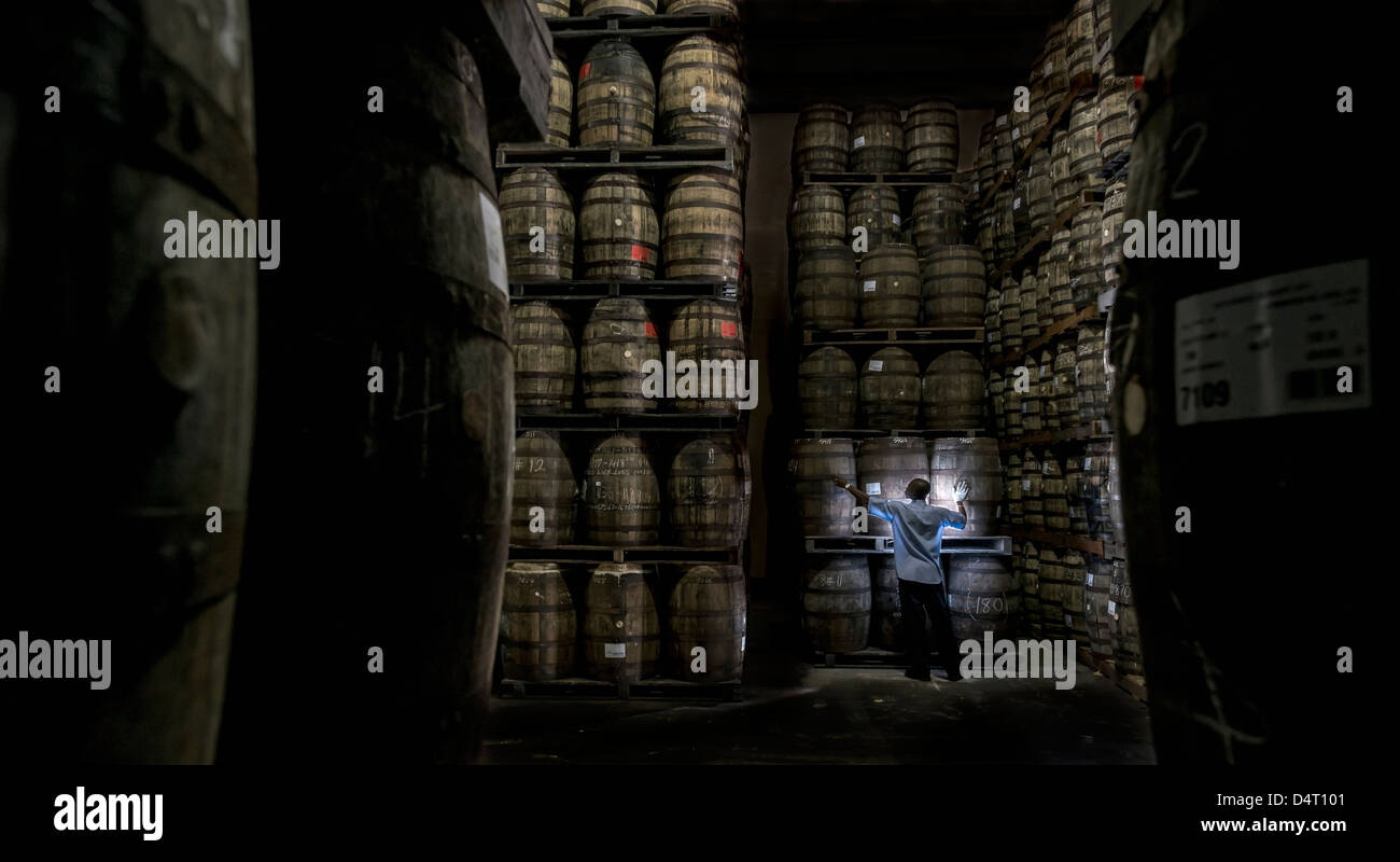 A distillery worker checks wooden barrels at the Mount Gay rum ...