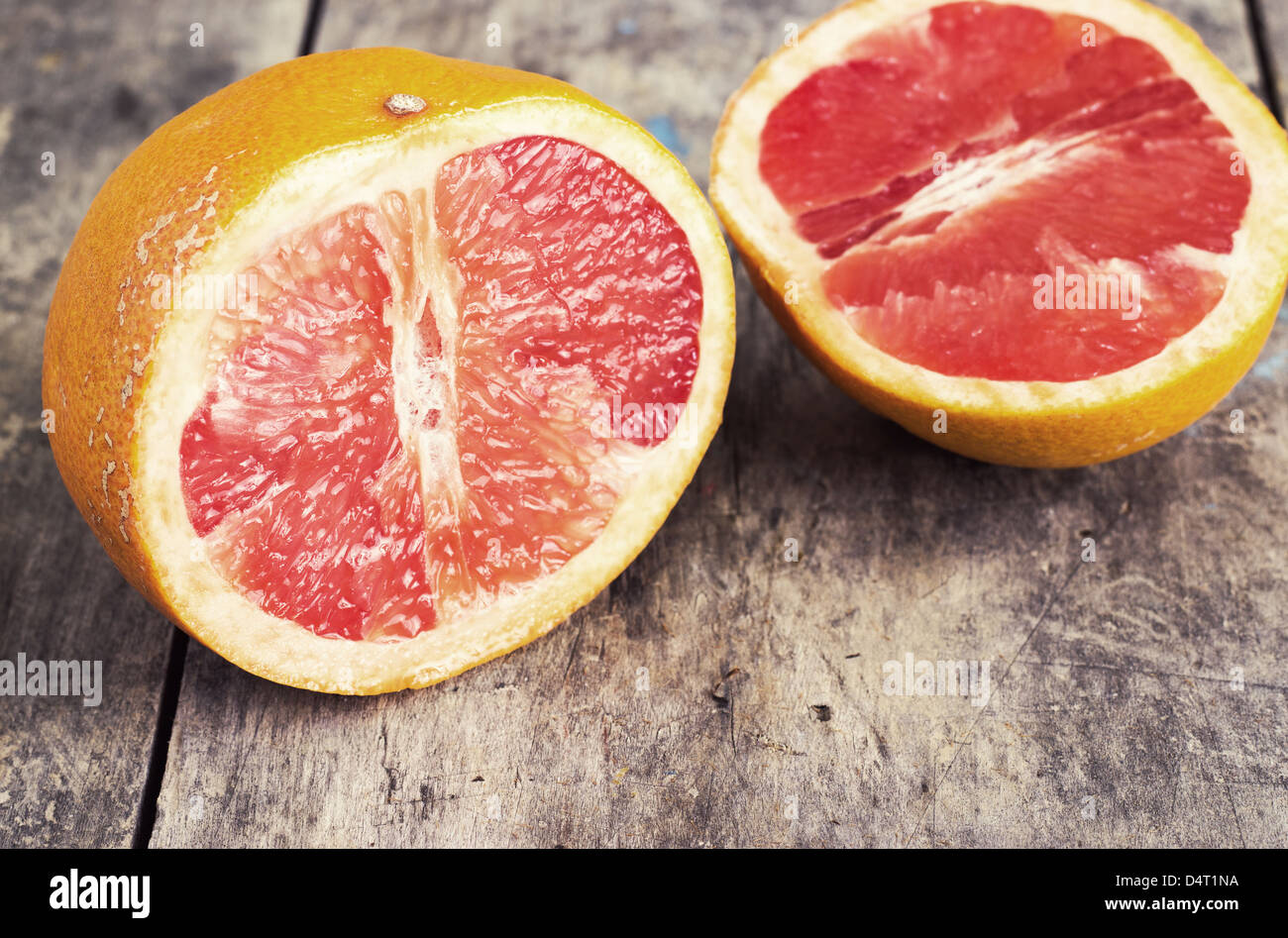 sliced red grapefruit on old table Stock Photo - Alamy