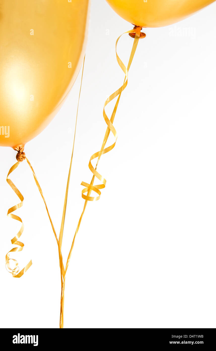 Gold balloons and ribbon on white background Stock Photo - Alamy