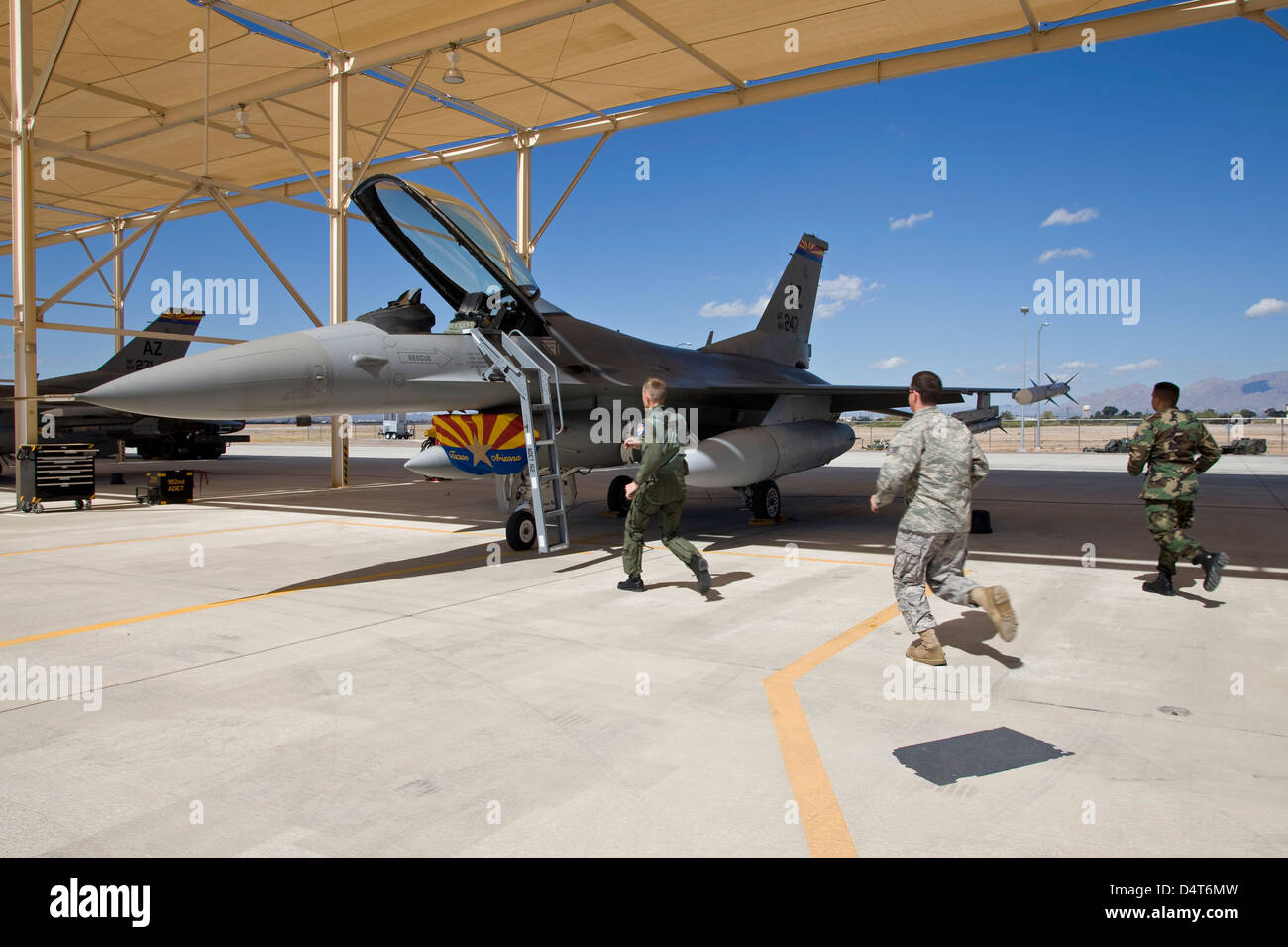 An alert crew scrambles to an F-16 to prepare it for takeoff Stock ...