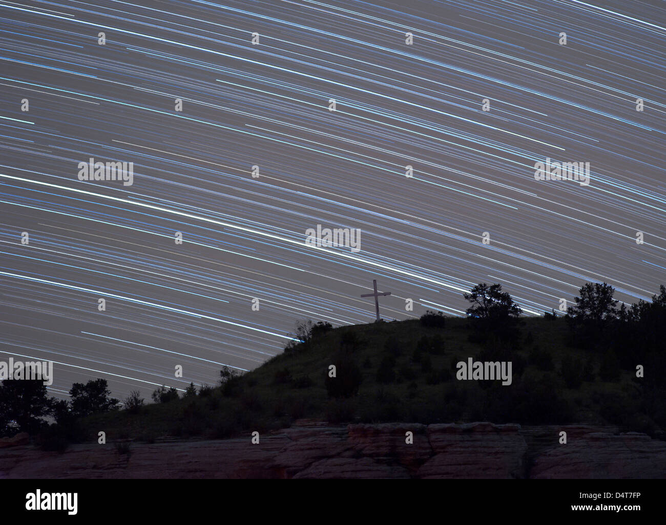 Star trails created by the Earth's spin arch over a cross on the hill ...