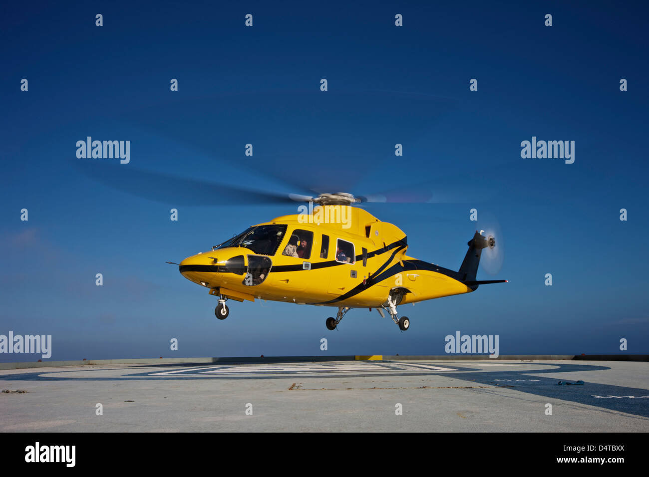 A Sikorsky S-76 utility helicopter taking off from the helipad on an ...