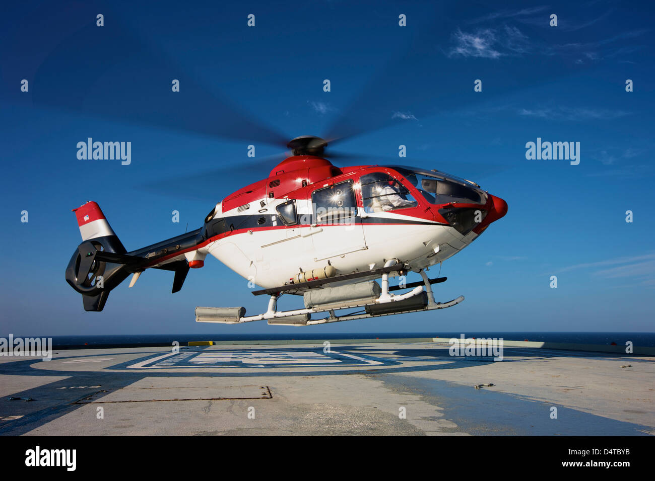 Eurocopter EC135 utility helicopter on the helipad of an oil rig in the ...