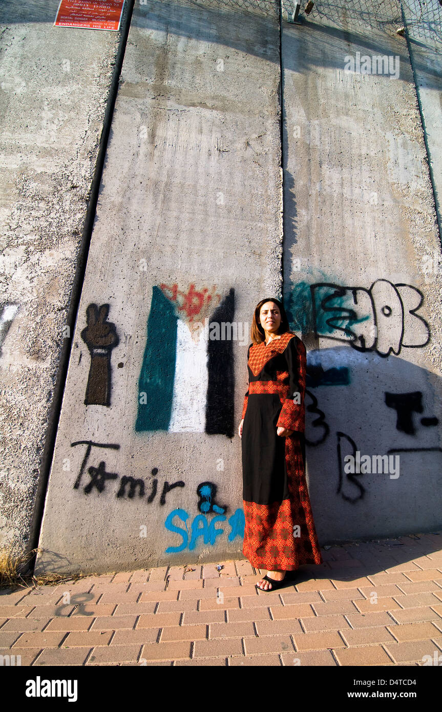 A proud Palestinian woman standing by the barrier built by the Israeli ...