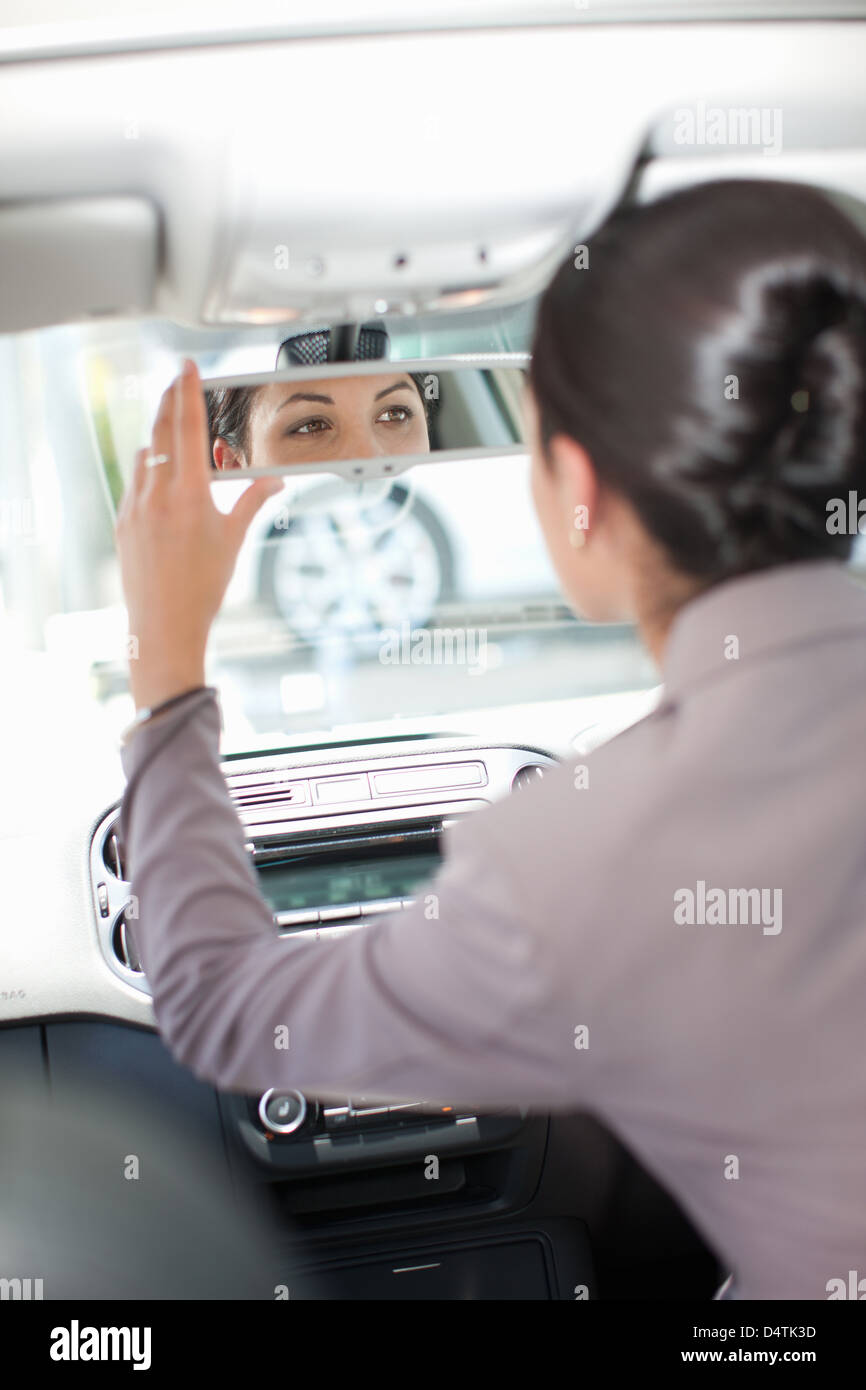 Woman adjusting rearview mirror in car Stock Photo - Alamy