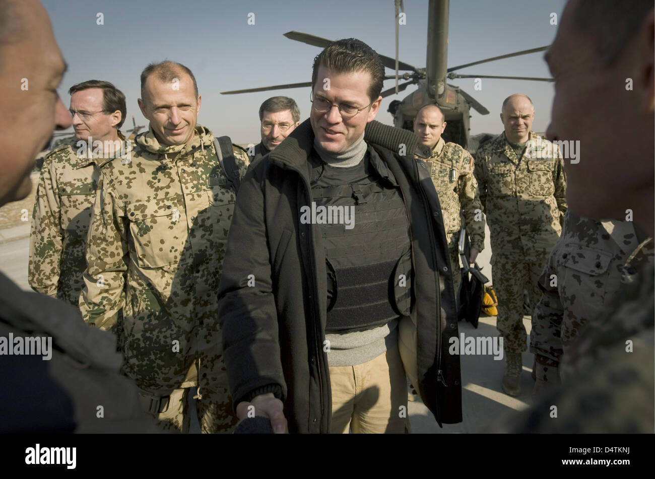 German Defence Minister Karl-Theodor zu Guttenberg (C) wears a ...