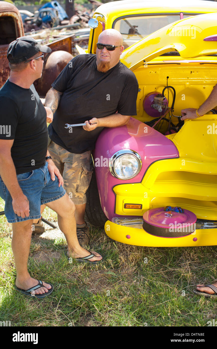 Mechanics working on colorful car Stock Photo - Alamy