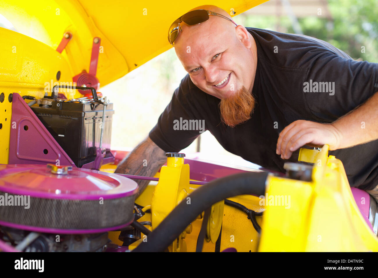 Mechanic working on colorful car Stock Photo - Alamy