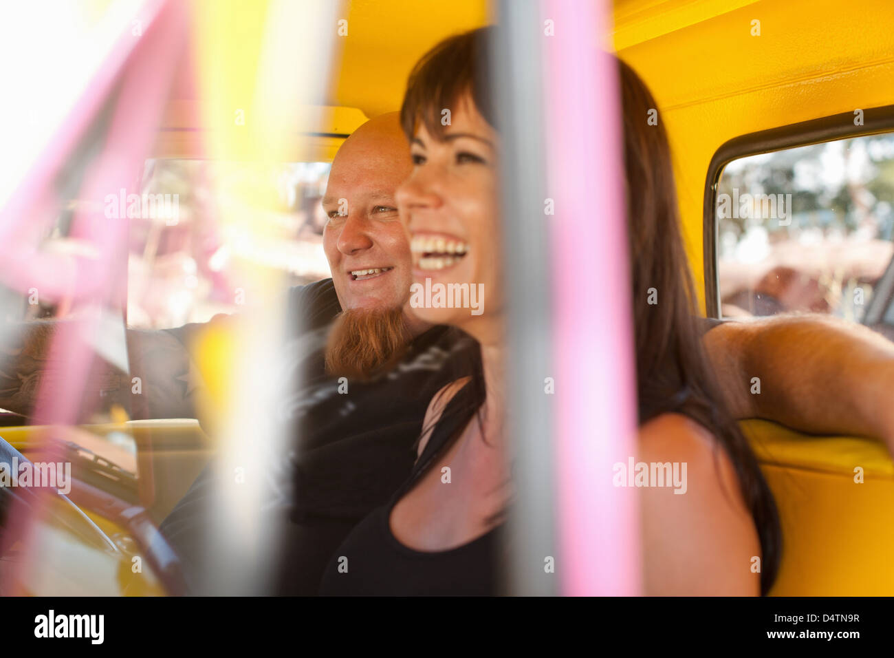Couple laughing in colorful car Stock Photo - Alamy