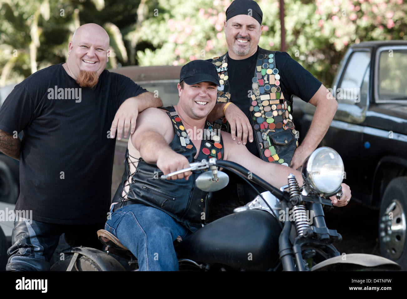 Men smiling around motorcycle Stock Photo - Alamy